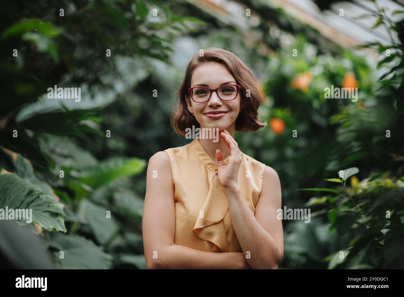 Beautiful woman standing in botanical garden, in the middle of lush ...