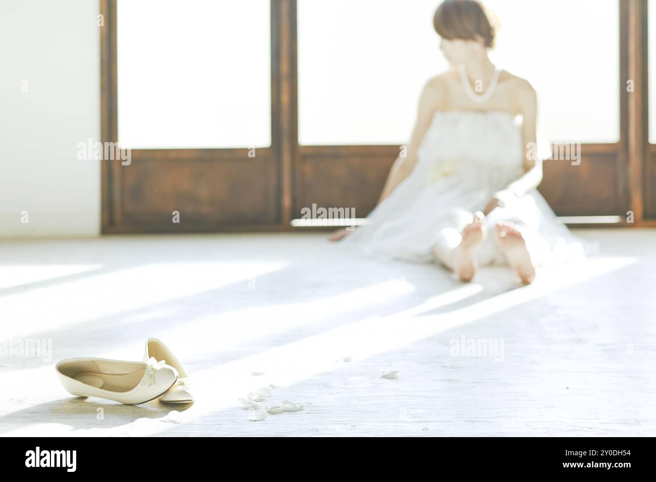 Bride sitting down by the window and shoes Stock Photo - Alamy