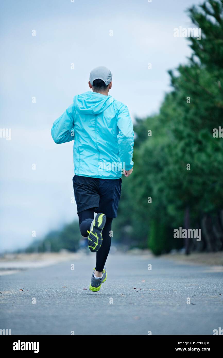 Back figure of running man Stock Photo - Alamy