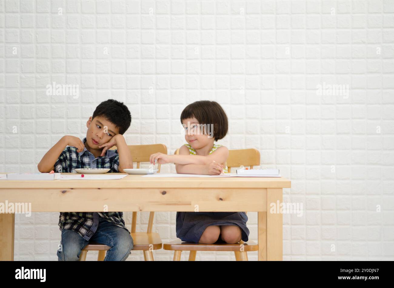 Children with worried look sitting on chairs Stock Photo - Alamy