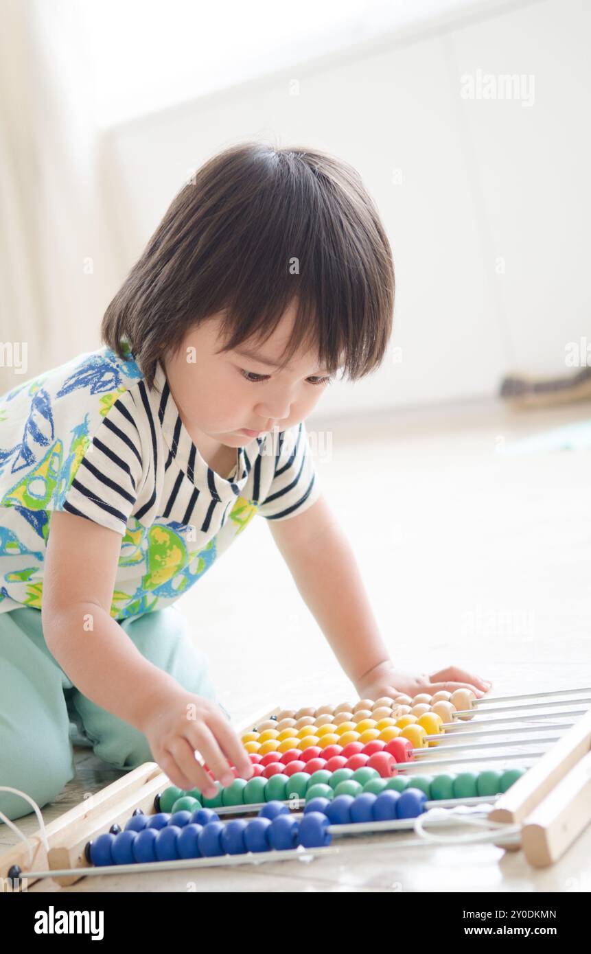 A boy playing with a one hundred ball abacus Stock Photo - Alamy