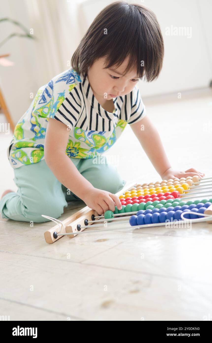 A boy playing with a one hundred ball abacus Stock Photo - Alamy