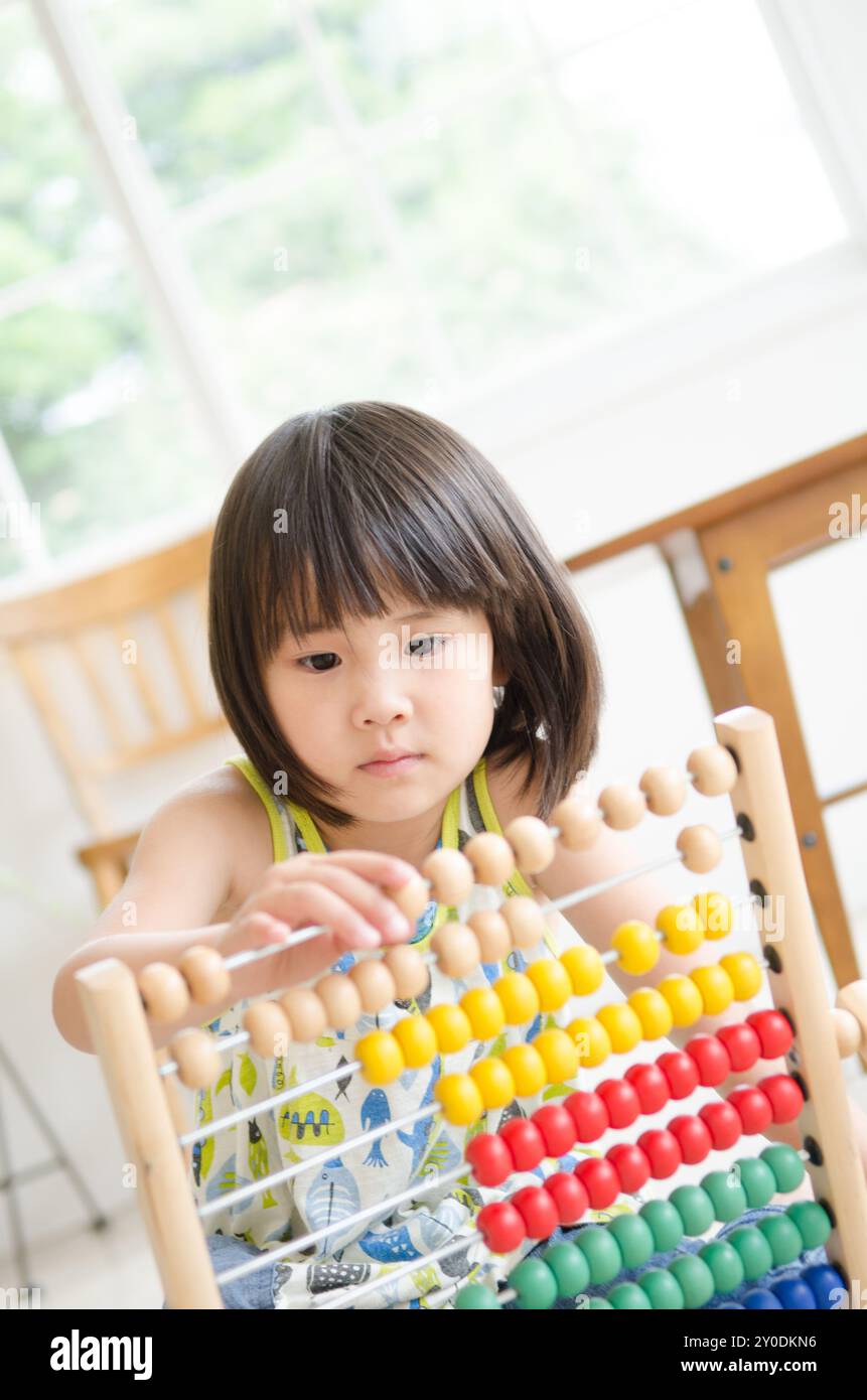 A girl playing with a one hundred ball abacus Stock Photo - Alamy