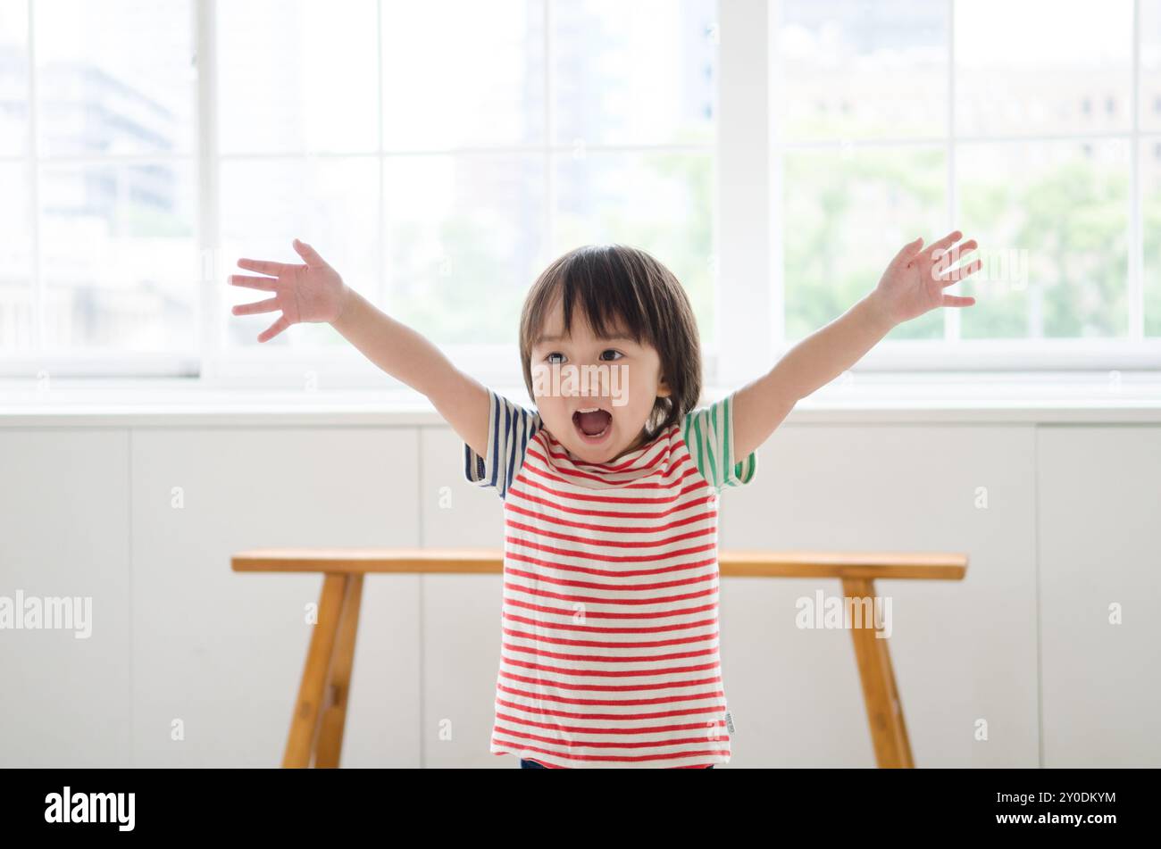 a boy raising both of his hands Stock Photo - Alamy