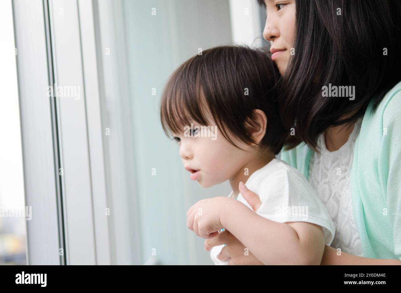 Children looking outside from a window Stock Photo - Alamy