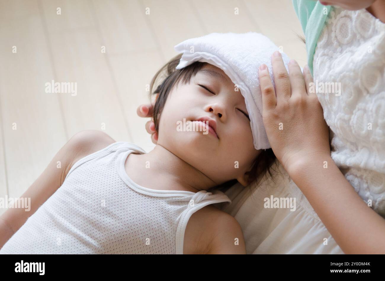A boy setting a towel above his forehead and closing his eyes Stock ...