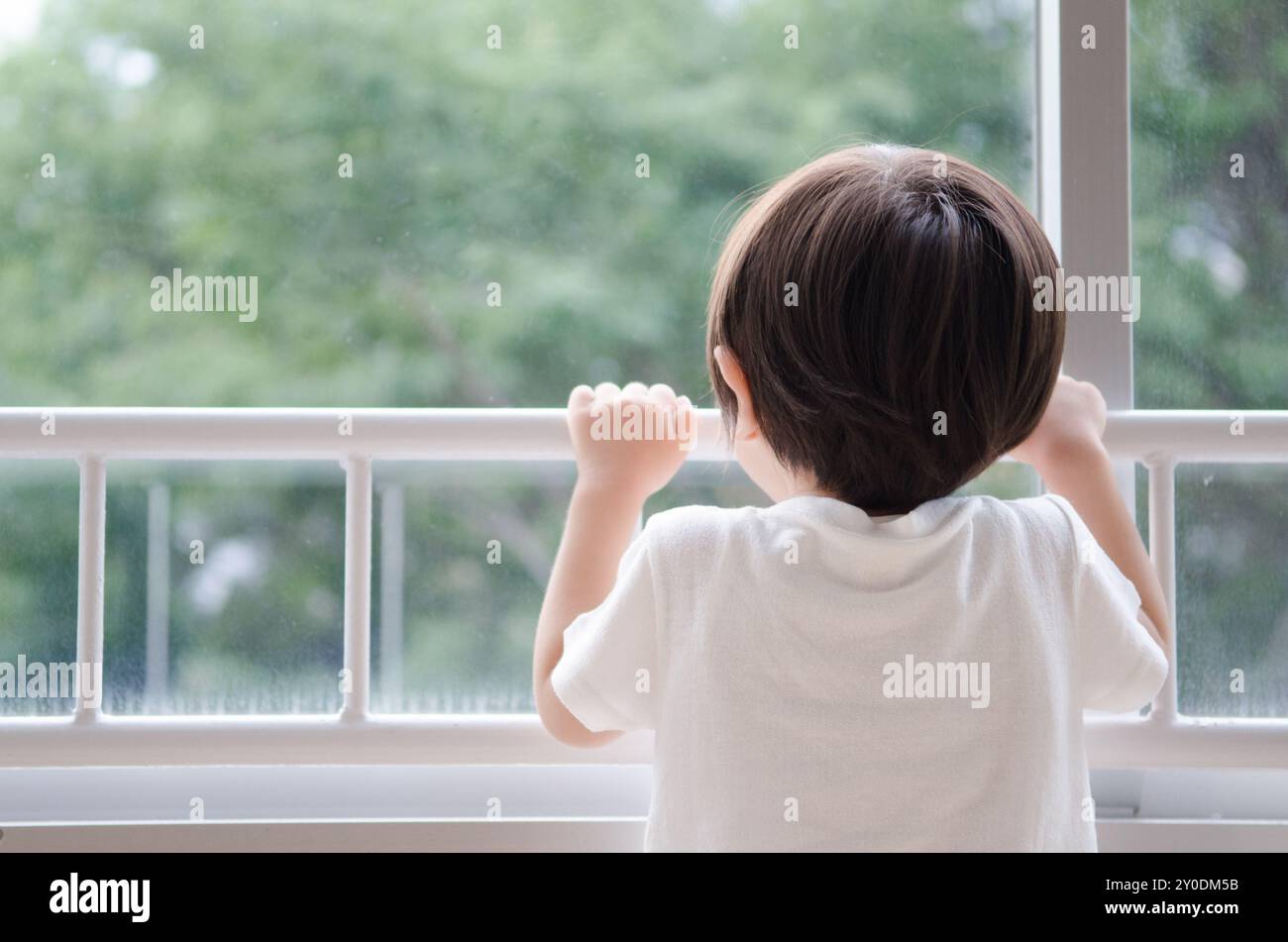 A boy looking out the window Stock Photo - Alamy