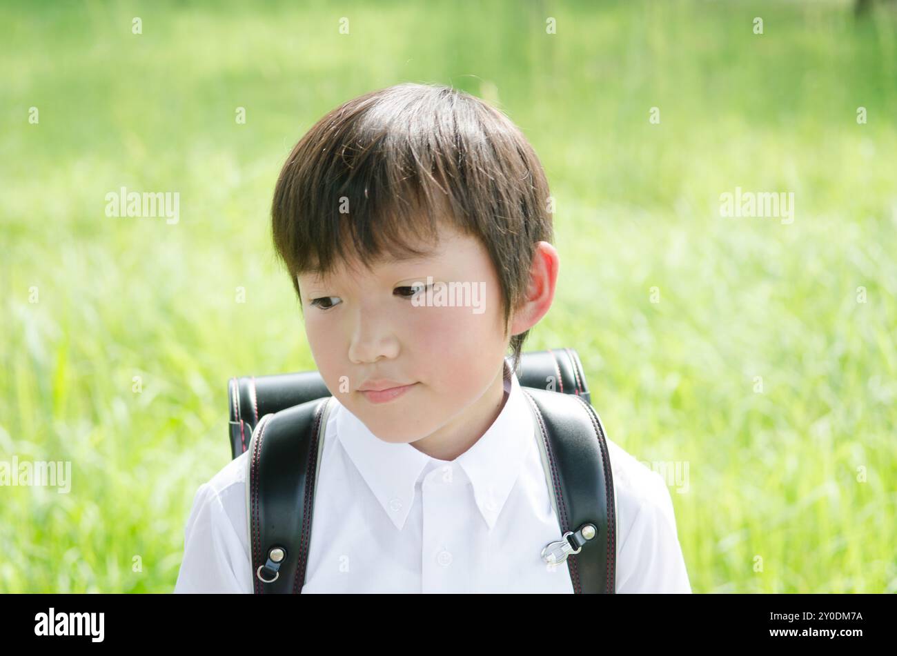 Boy carrying a backpack on the back,?looking down Stock Photo - Alamy