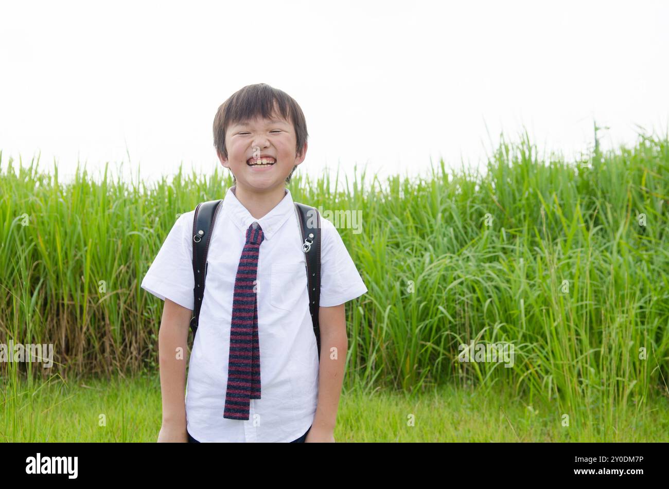 Boy carrying backpack on the back and laghing Stock Photo - Alamy