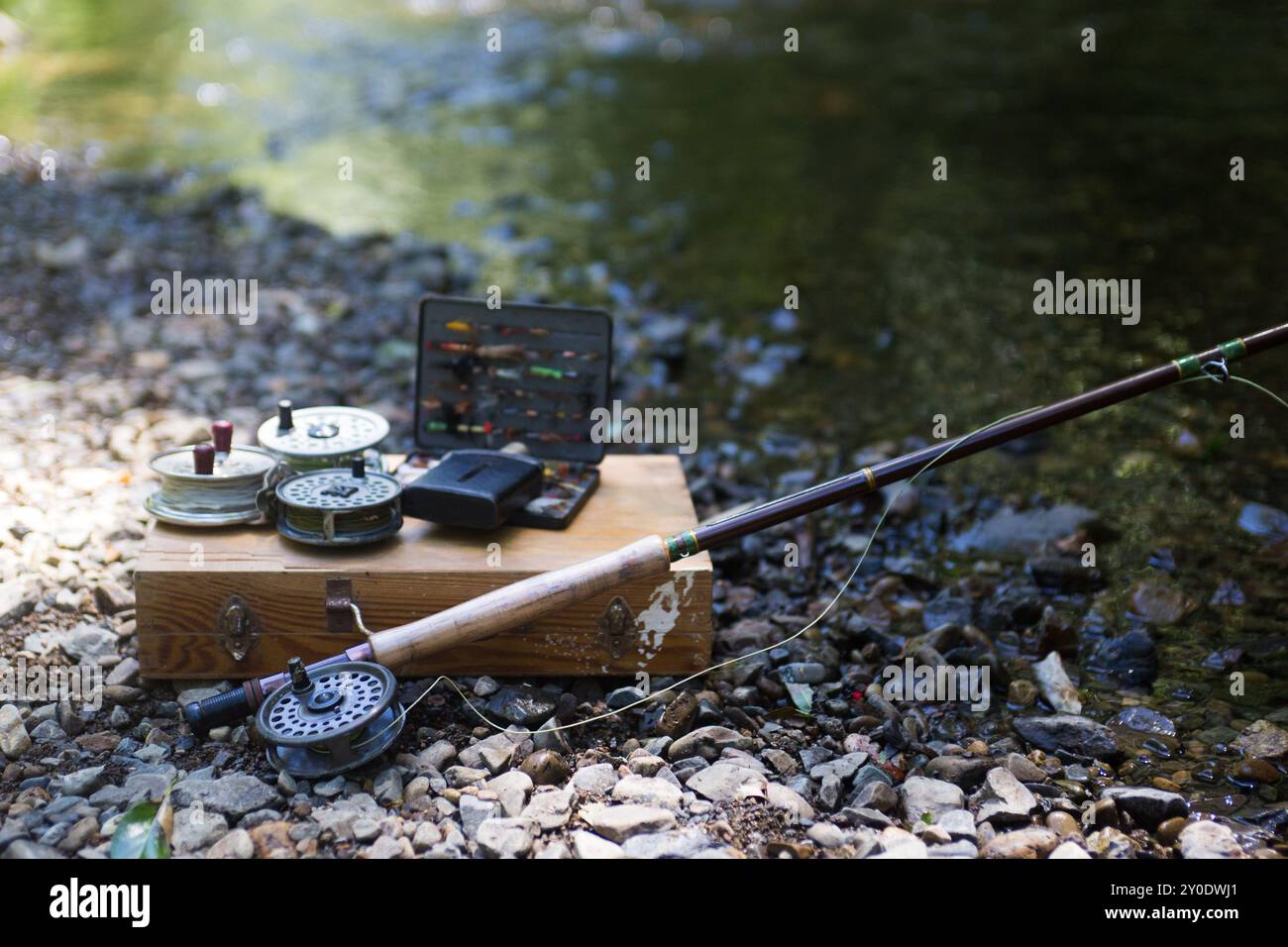Fly fishing, tackle box and a rod Stock Photo - Alamy