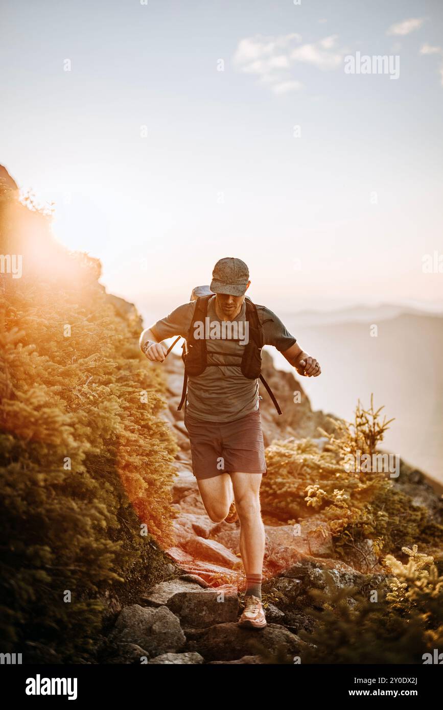 male runner on rocky trail at sunset above treeline in mountains Stock ...