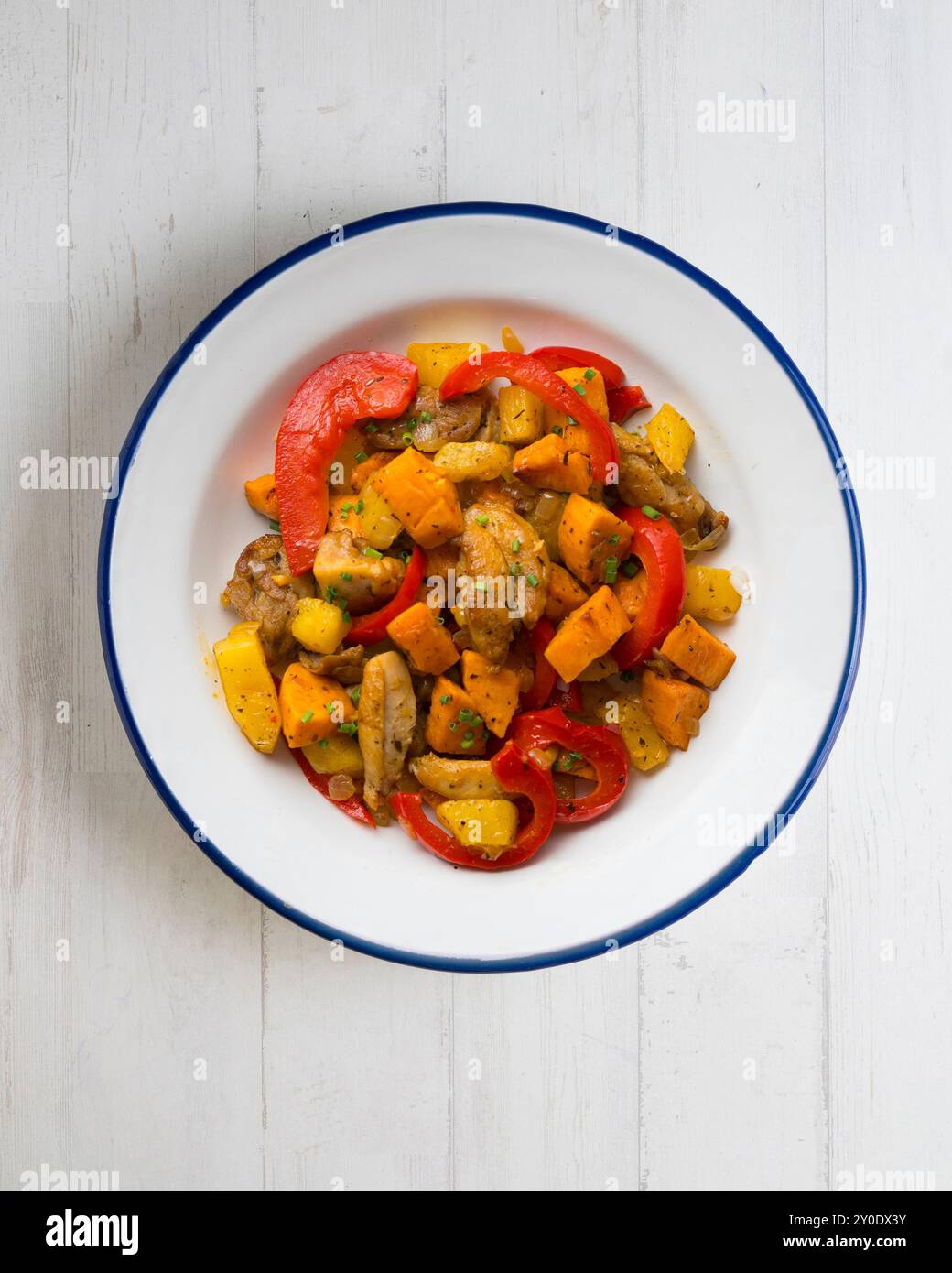 Stir-fried chicken with sweet potato and red pepper. Top view table ...
