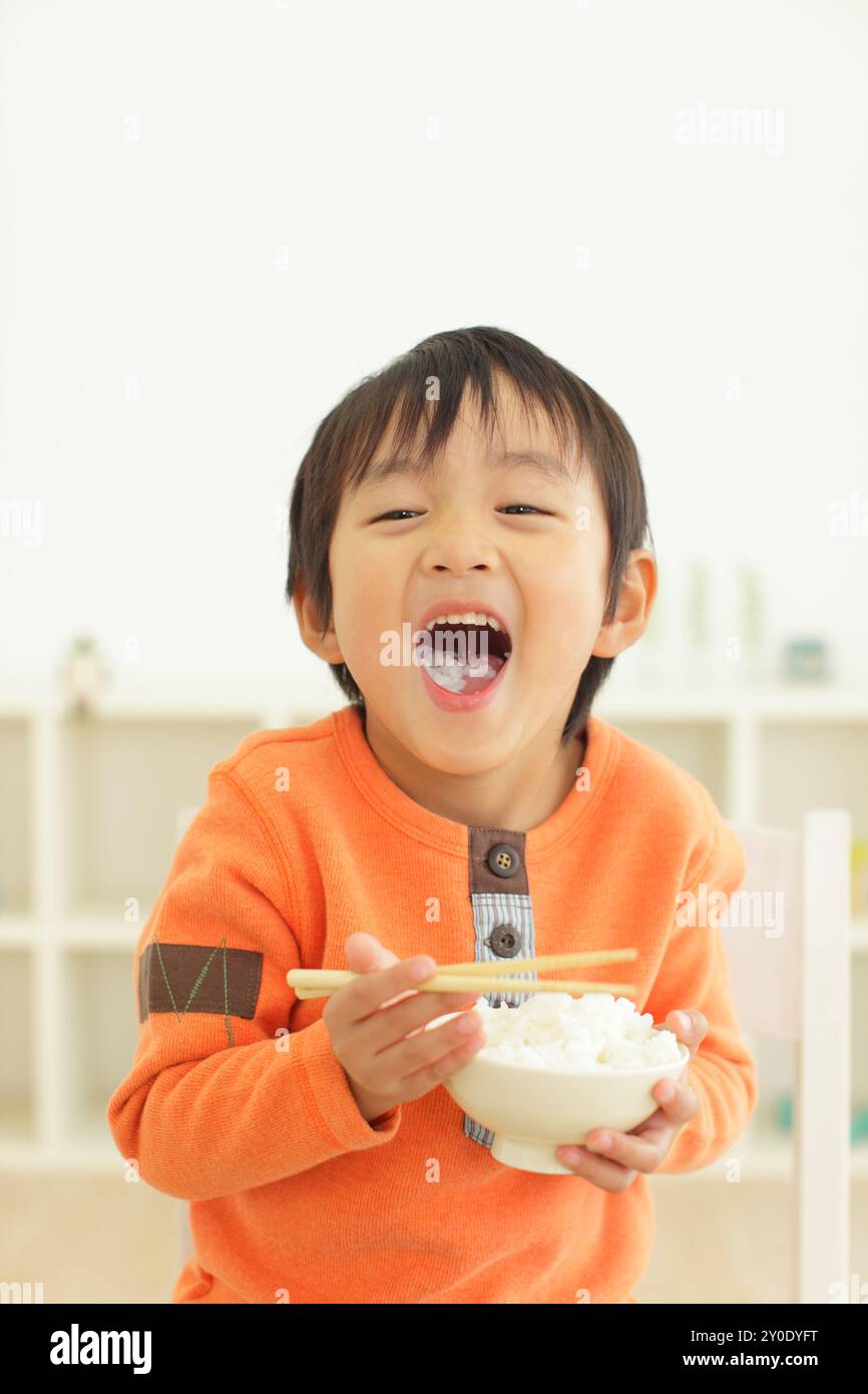 Boy eating rice Stock Photo - Alamy