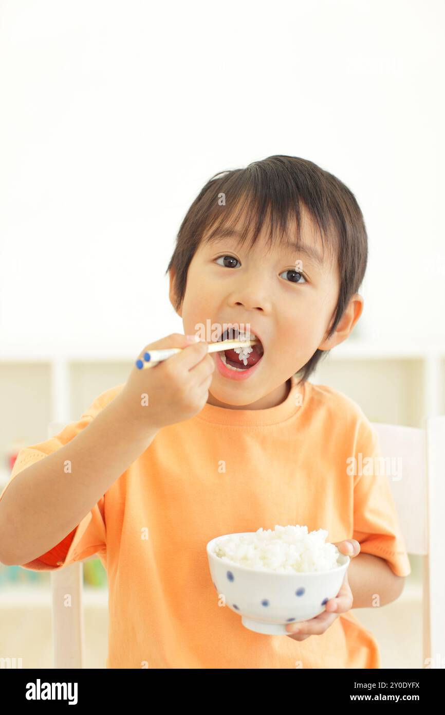 Boy eating rice Stock Photo - Alamy
