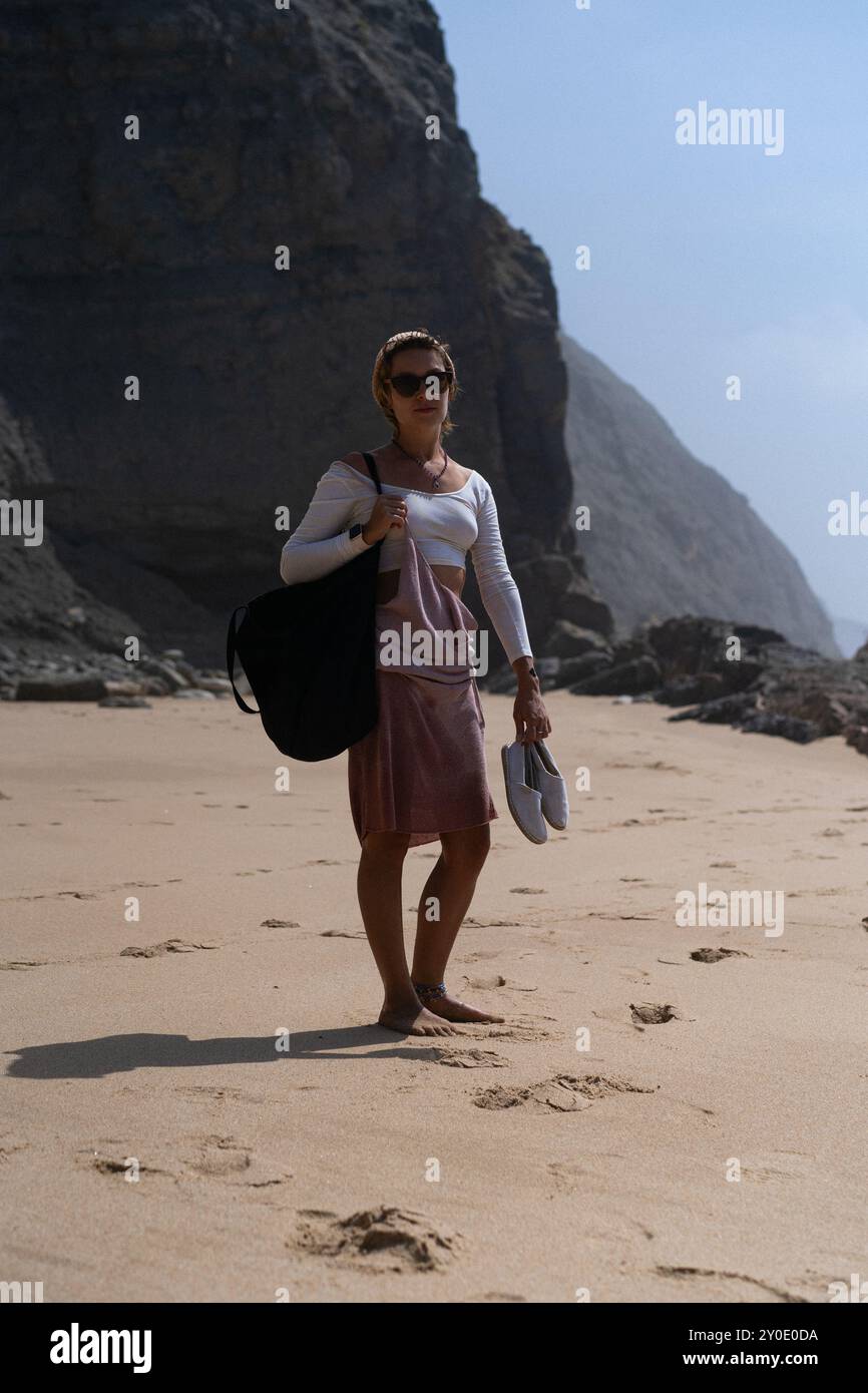 Young woman on cliff looking out over ocean in summer in Portugal Stock ...