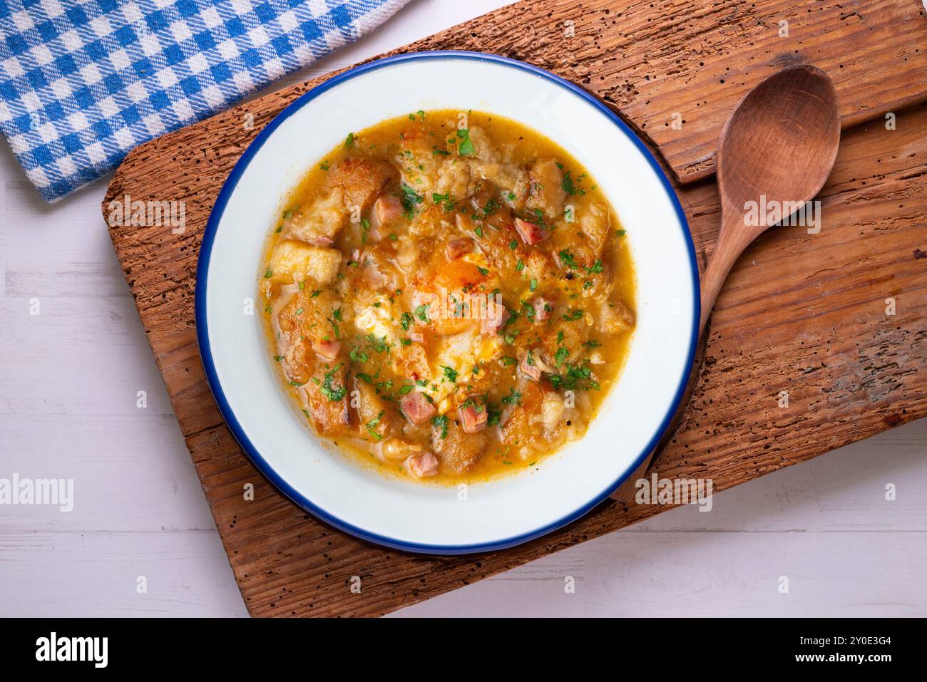 Castilian soup with vegetables, bread croutons and egg. Top view table ...