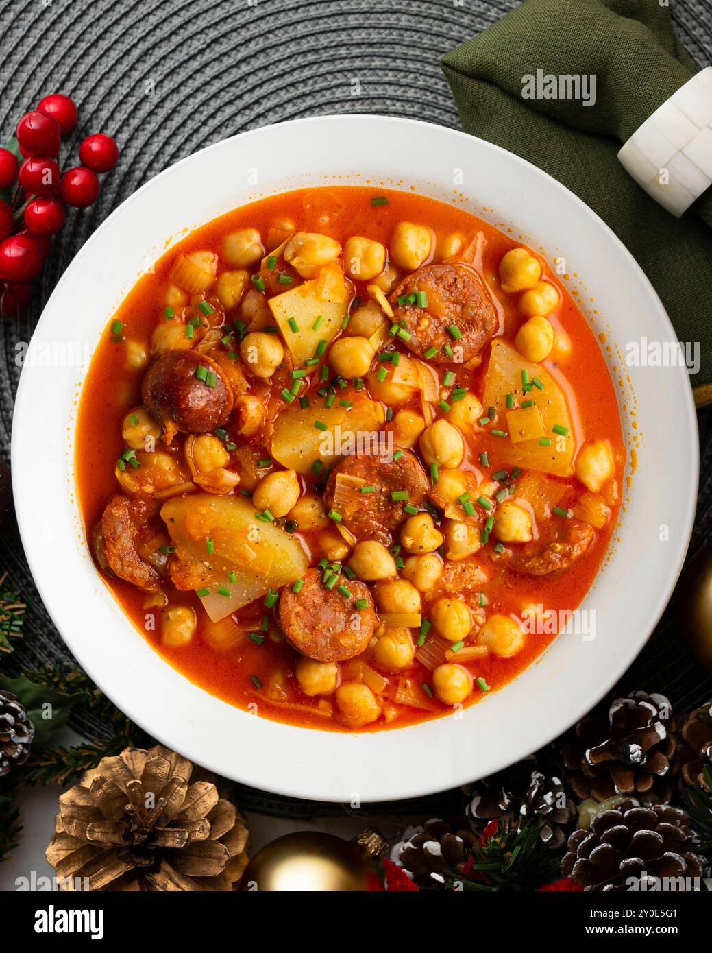 Delicious dish of braised chickpeas with spicy chorizo. Table with ...