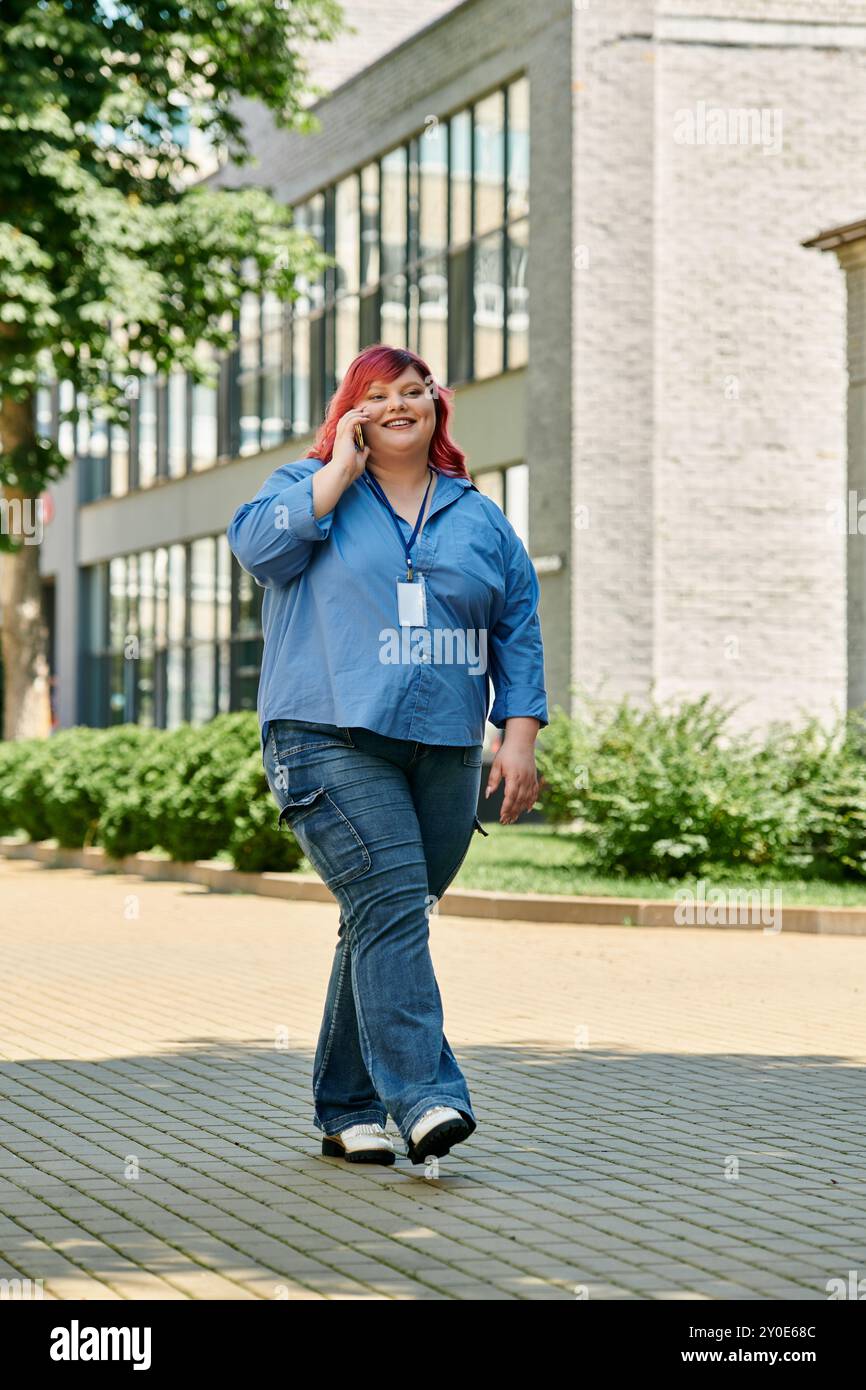 A plus size woman with pink hair walks down a city street, talking on ...