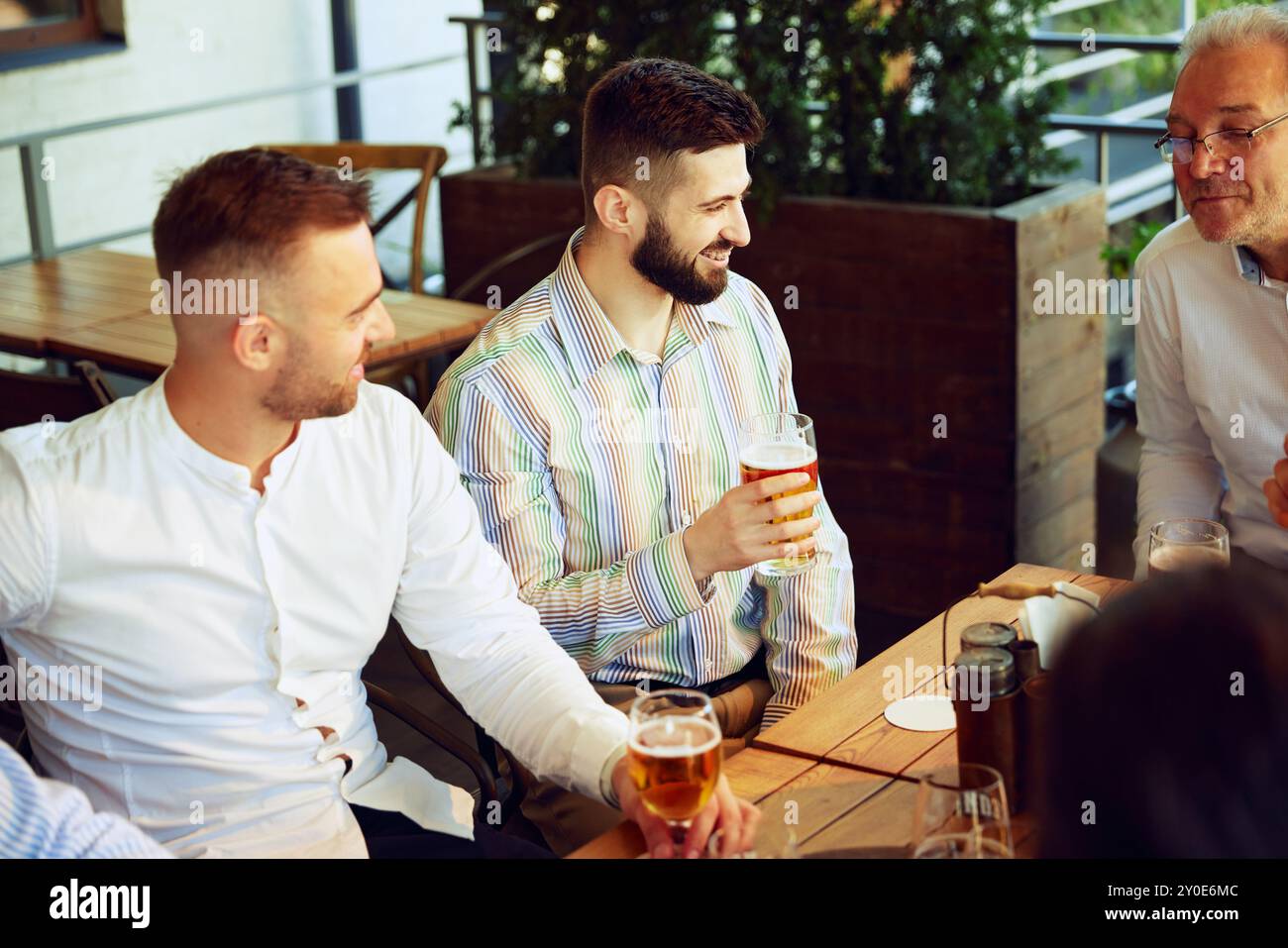 Business people, positive men, colleagues meeting at outdoor bar ...