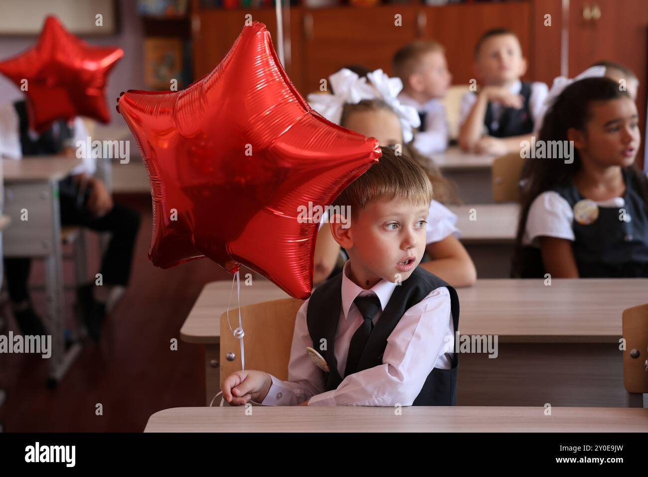 First graders sit in a classroom after a ceremony marking the start of ...