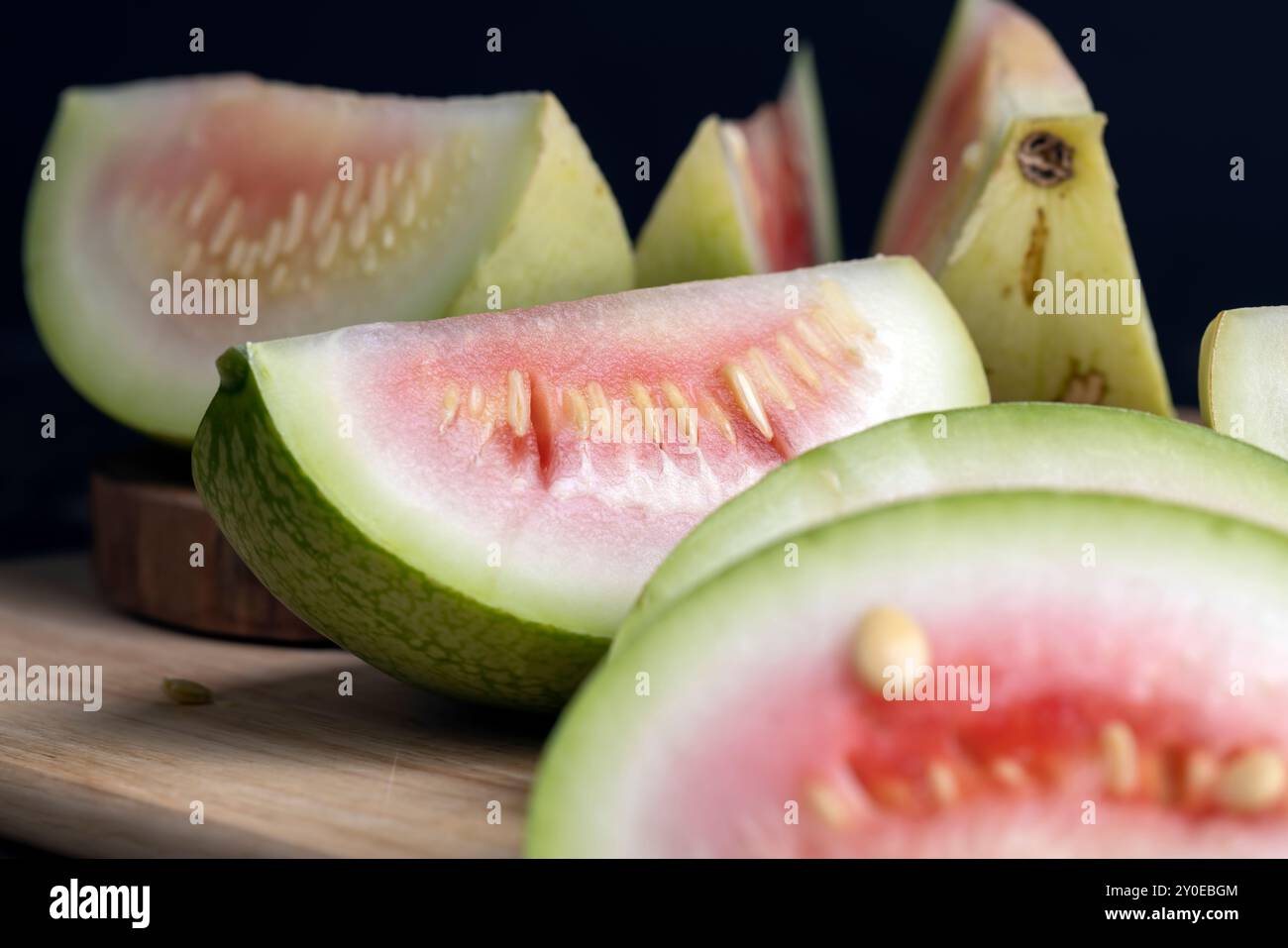 cut small unripe watermelon on a board, cut into pieces unripe ...