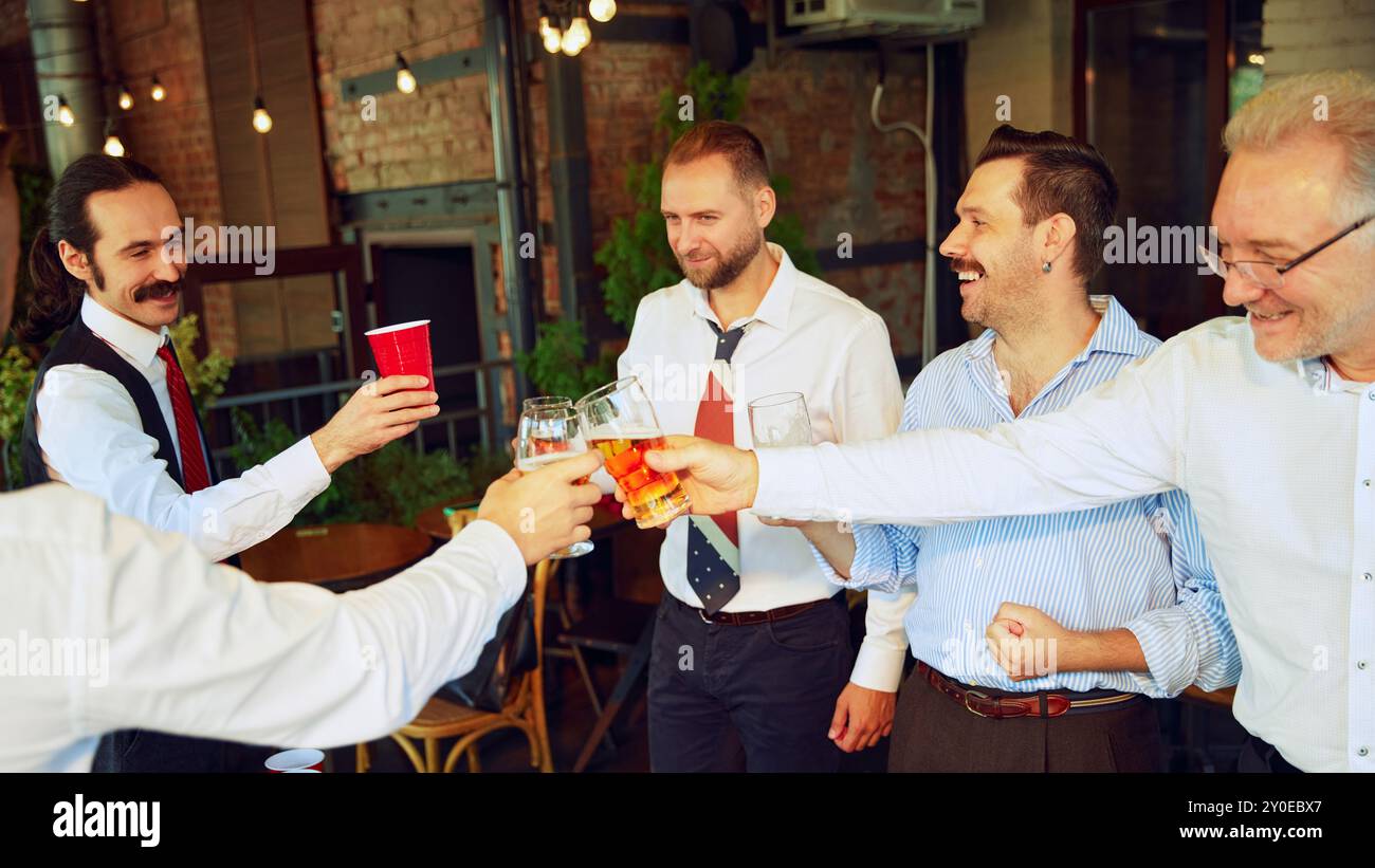 Relaxing meeting, businessmen in formal wear gathering at outdoor bar ...