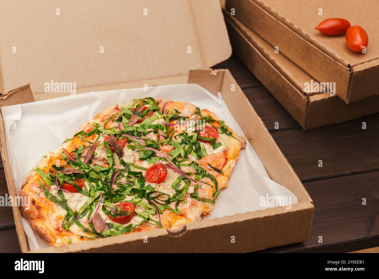 Italian pizza topped with anchovy, capers, red onion in open delivery ...