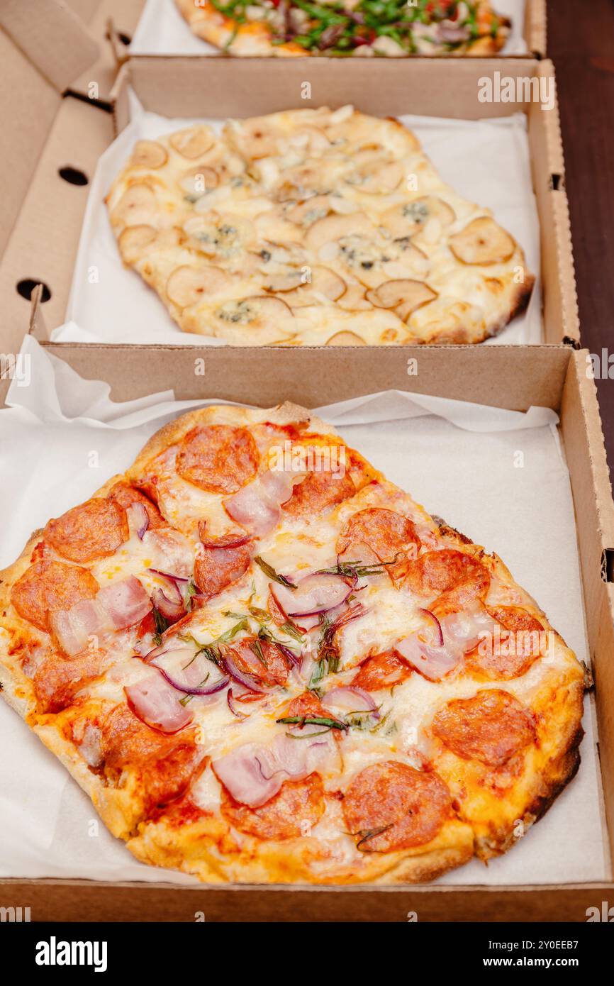 Variety of pizzas in open cardboard delivery boxes, pepperoni pizza and ...