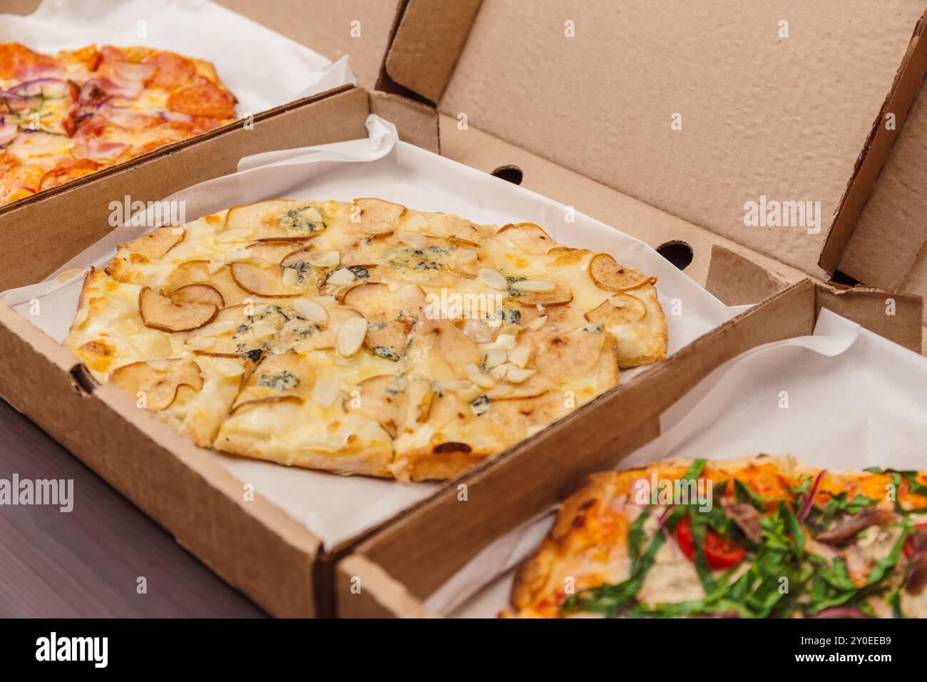 Assorted pizzas in delivery boxes, pear and blue cheese pizza, ready to ...
