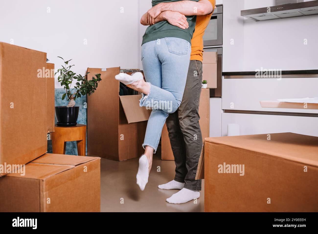 Family lift and spins joyfully between moving boxes, celebrating their ...
