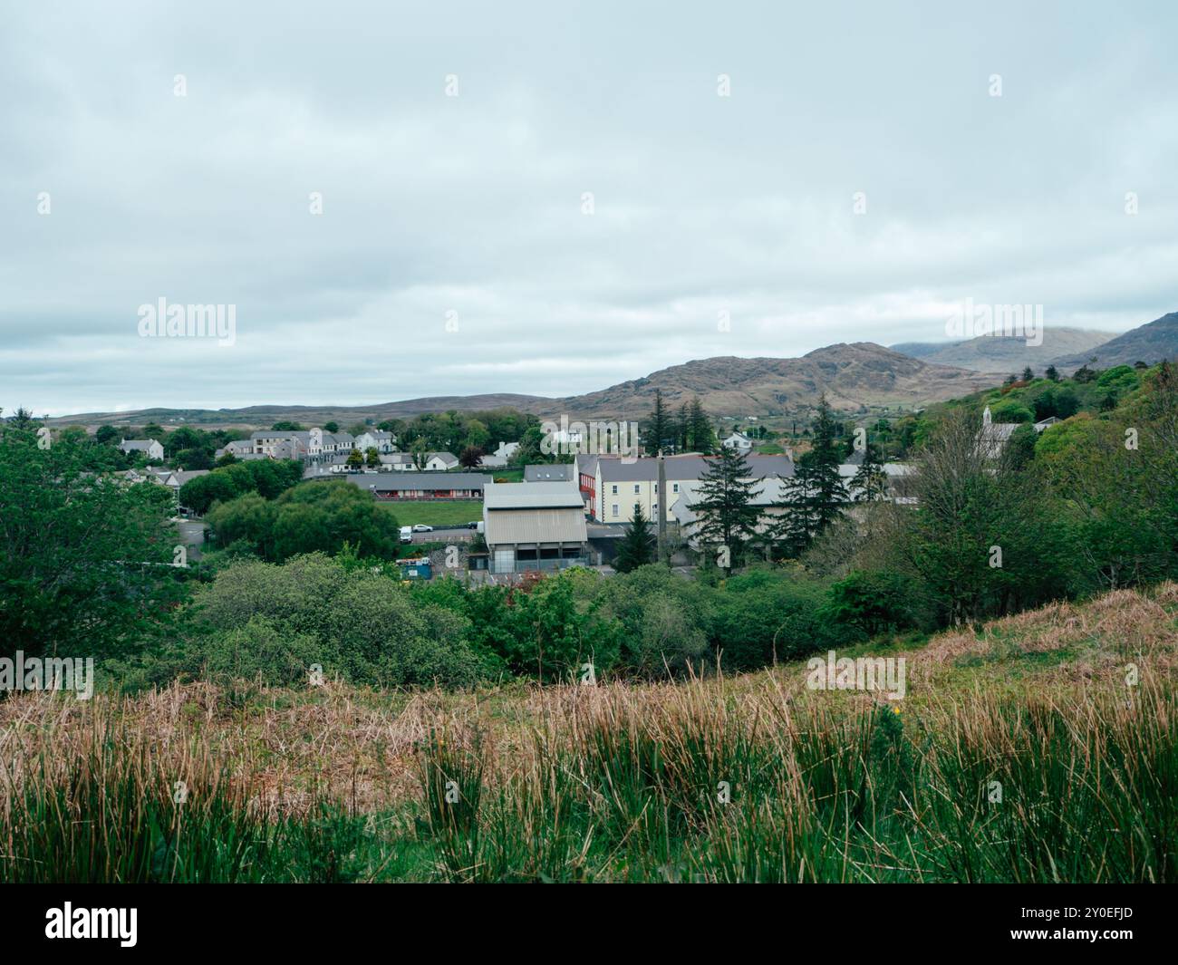 The landscape features a picturesque village surrounded by greenery and ...