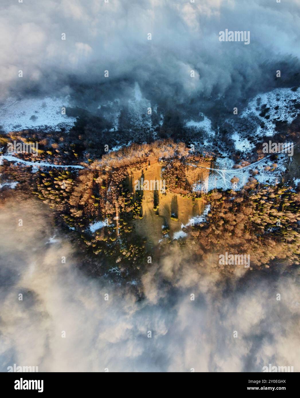 Aerial view capturing winding path through snowy, mist-covered ...