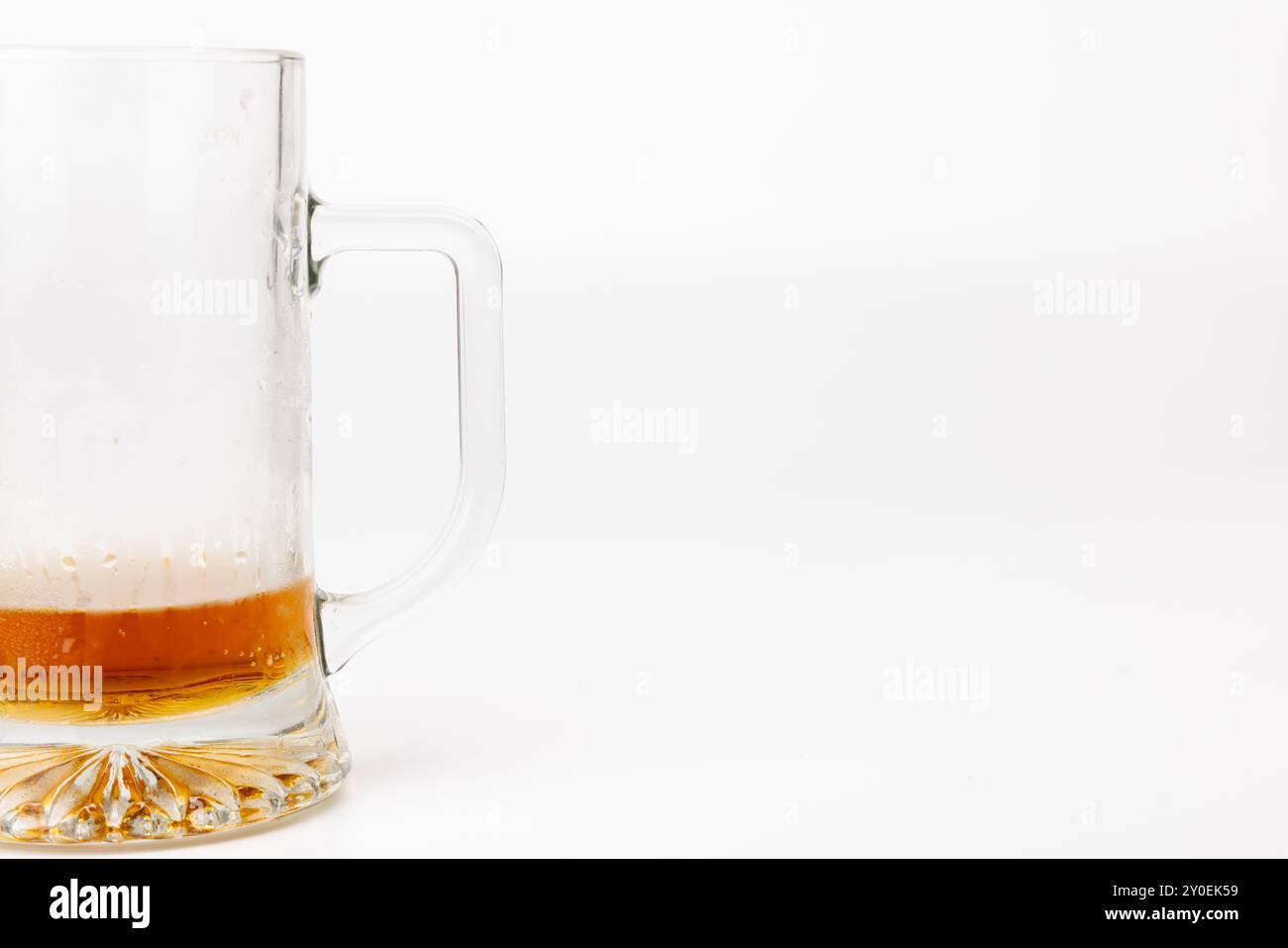 A horizontal image featuring a half-empty, frosted beer mug with dark ...