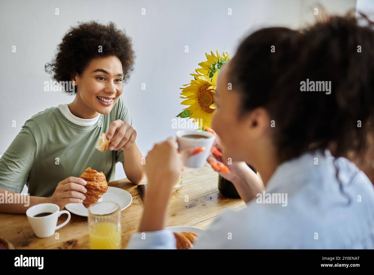 A loving couple enjoys brunch together, sharing smiles and pastries ...