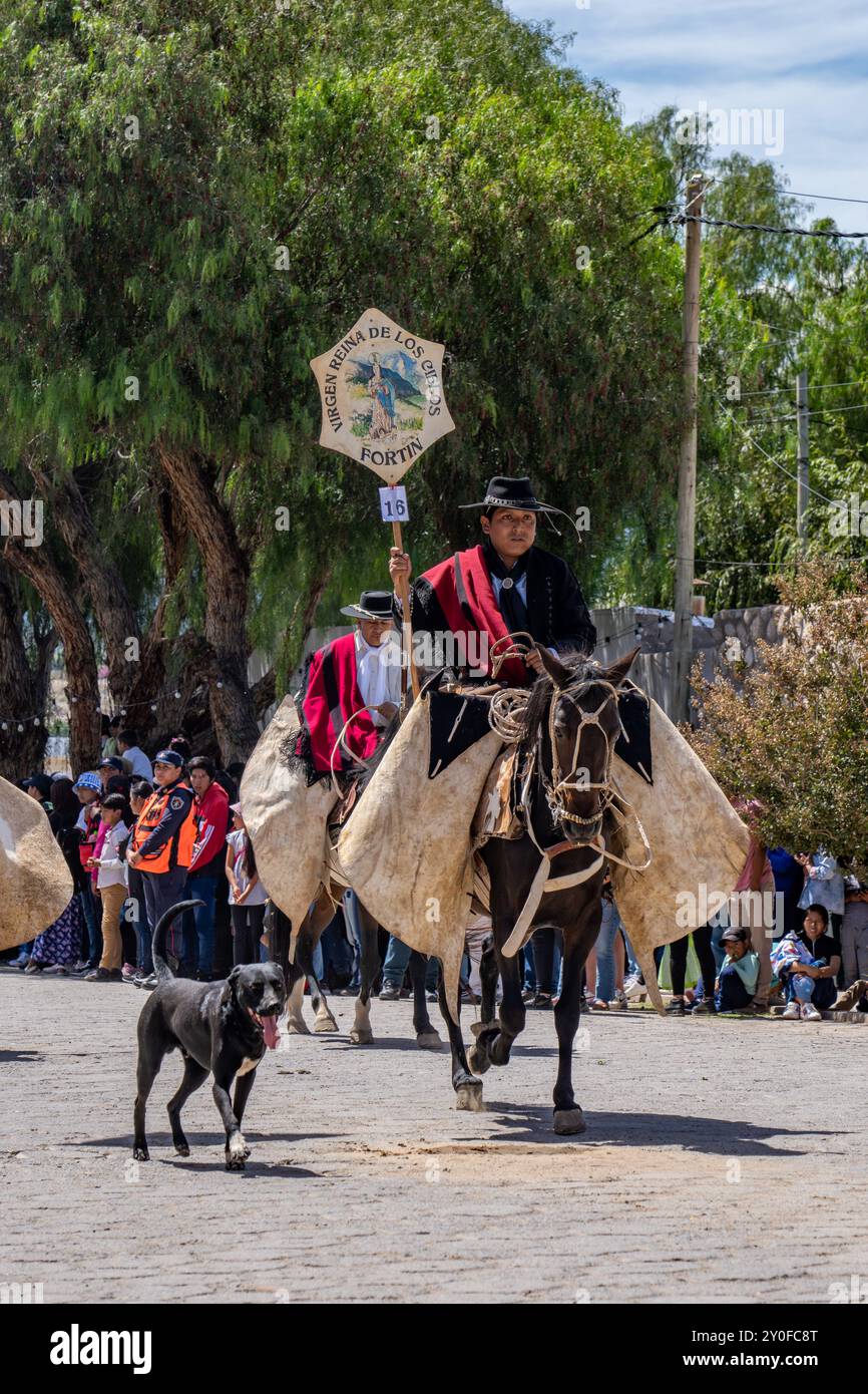 Gauchos in traditional outfits riding on horseback in a parade in Cachi ...