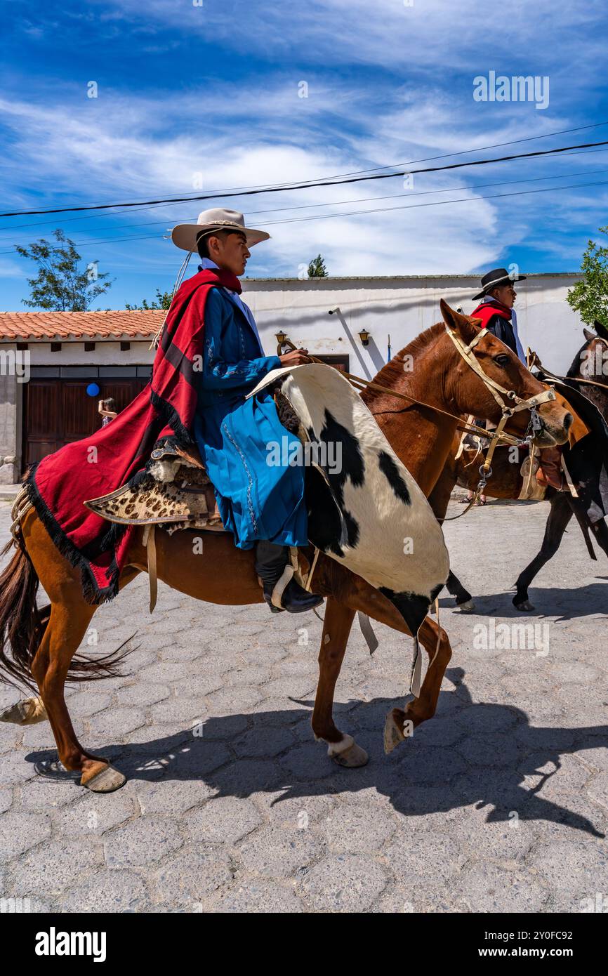 Gauchos in traditional outfits riding on horseback in a parade in Cachi ...