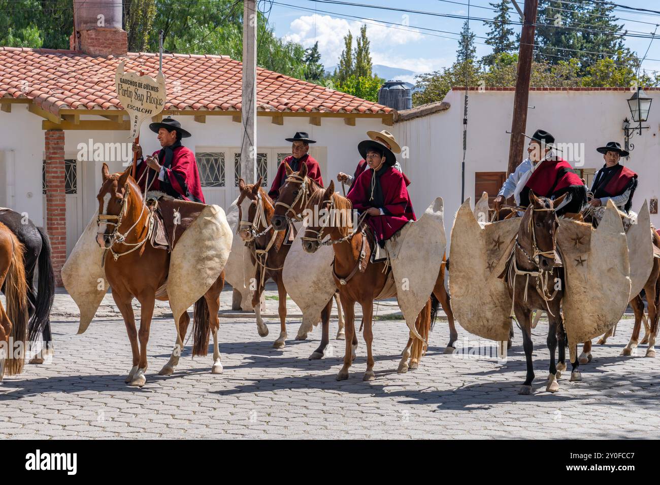 Gauchos in traditional outfits ride in on horseback for a parade in Cachi, Argentina. Cowhide ...