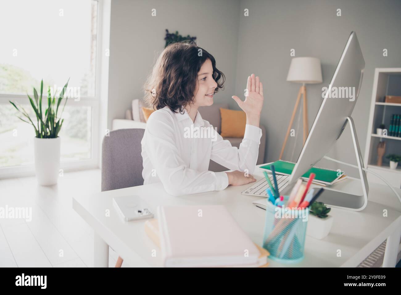 Photo of charming smart little boy pupil wearing white shirt learning ...