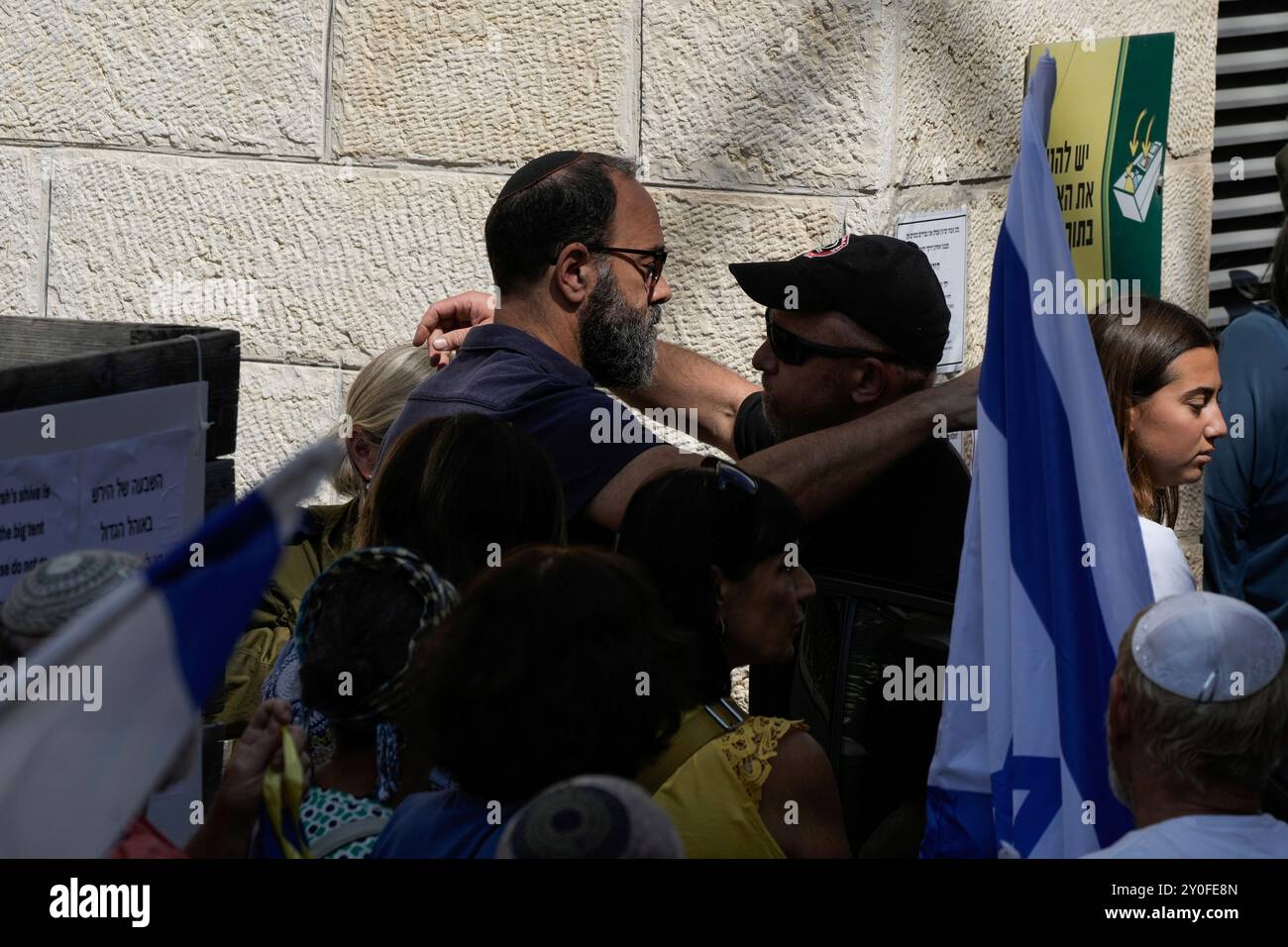 A mourner comforts Jon Polin, left, father of Israeli-American hostage ...