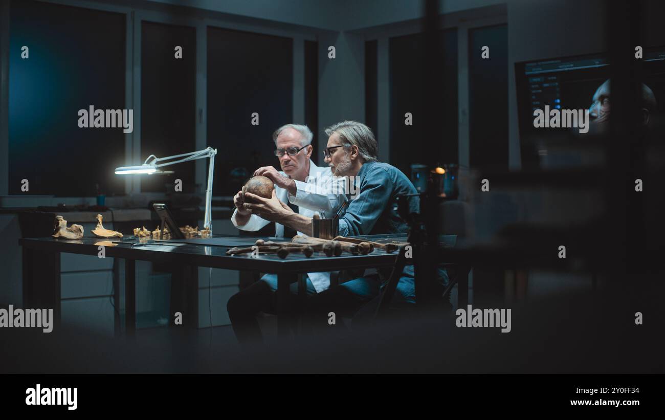 Two archaeologists examine skull of prehistoric human, conduct ...