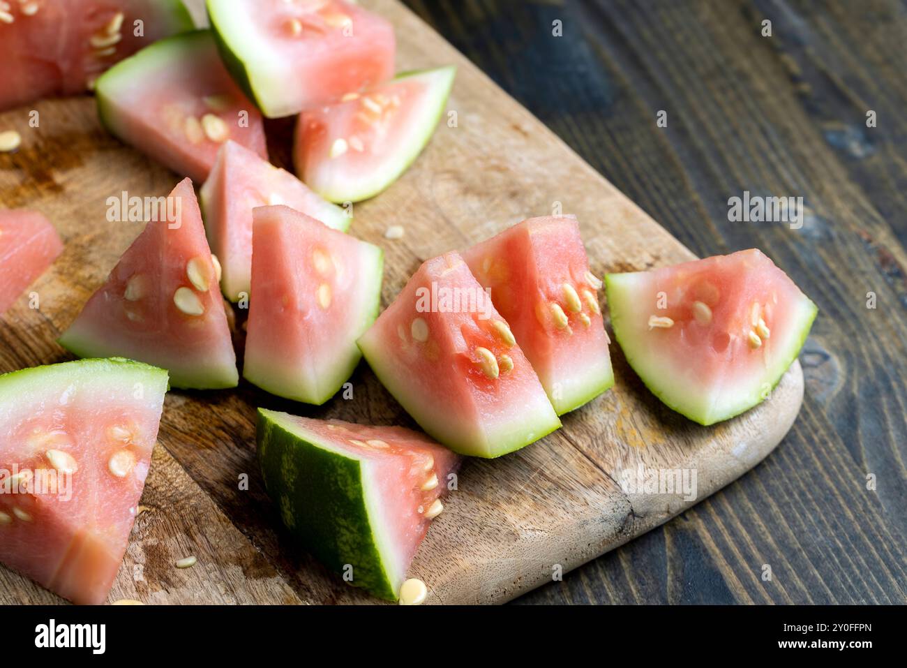Unripe watermelon of small size with large white seeds and light pink ...