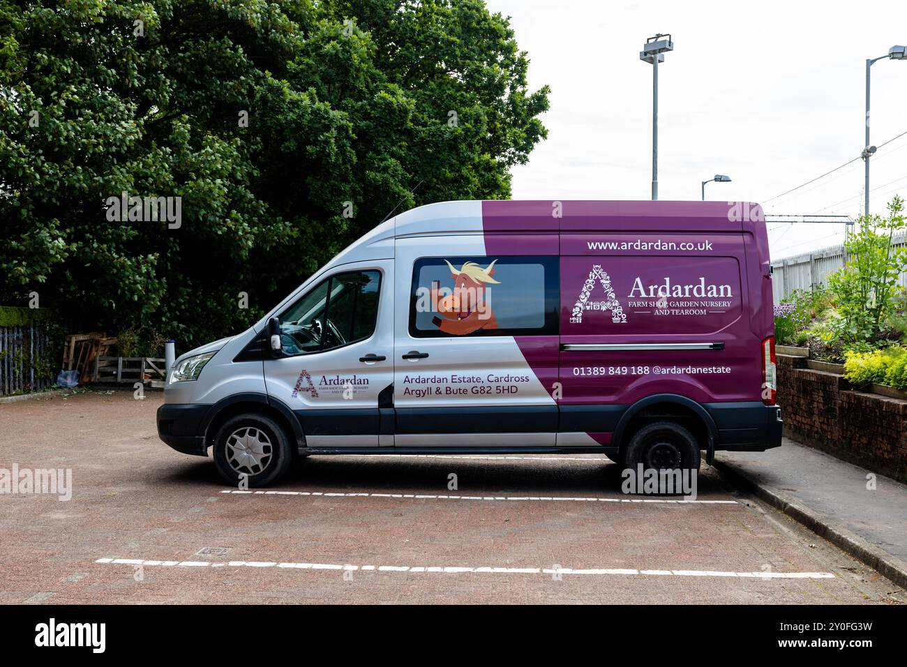 A colorful van with maroon and silver livery is parked in a car park or ...