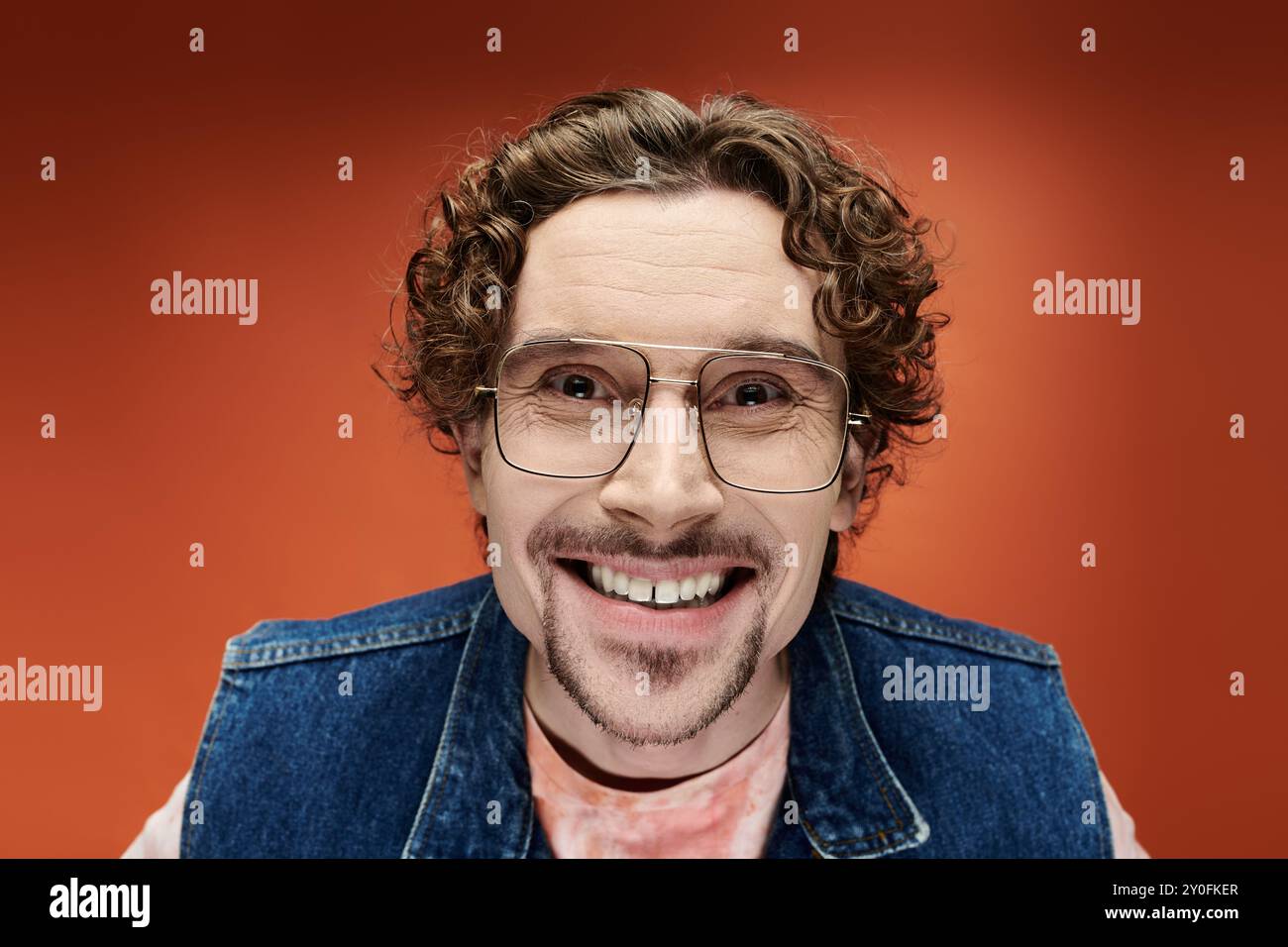 A cheerful man showcases an infectious smile in front of a colorful ...