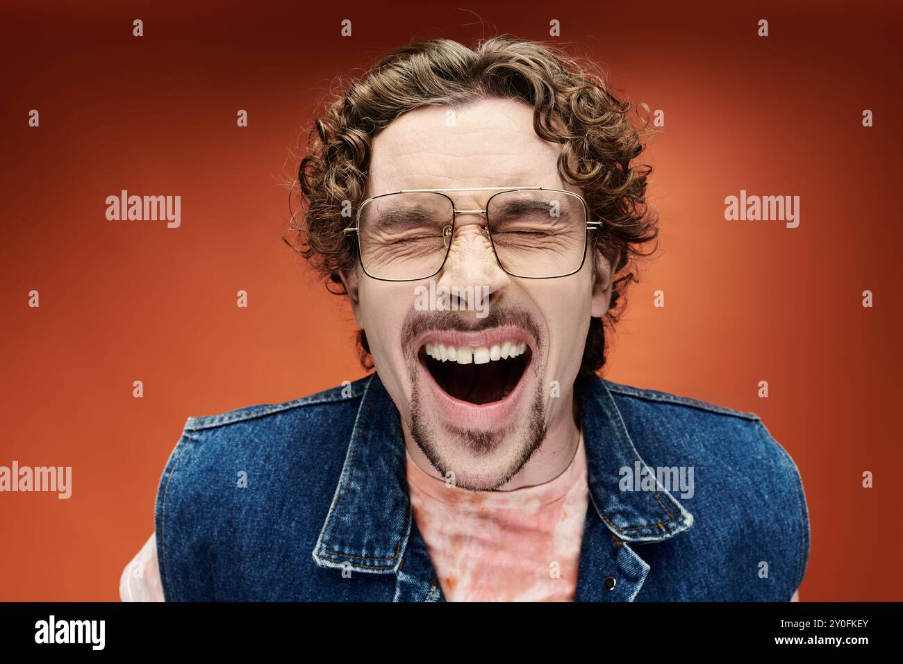 A cheerful man beams joyfully while posing in front of a bright ...