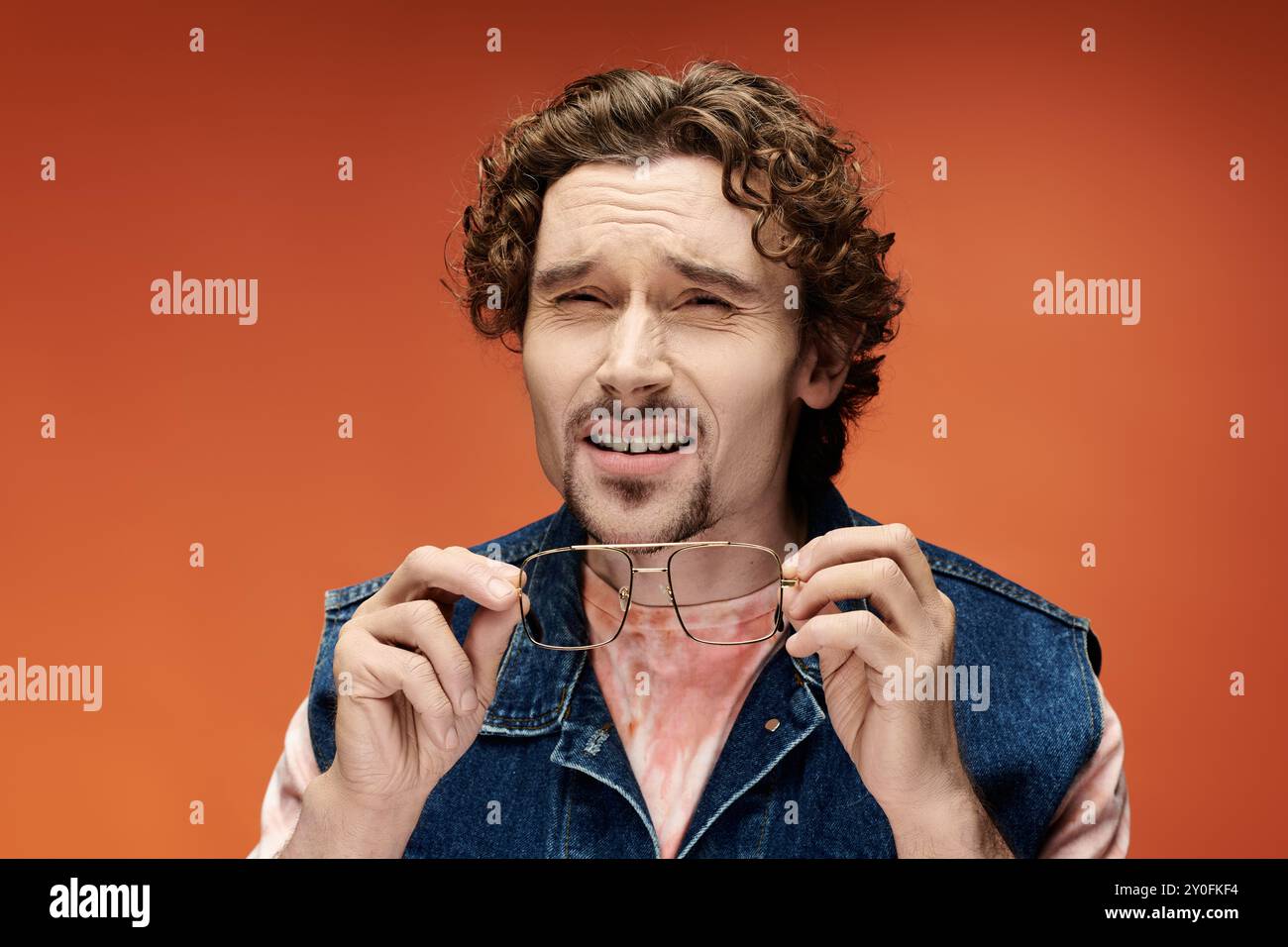 A handsome man holds glasses, reflecting deep emotion and contemplation ...