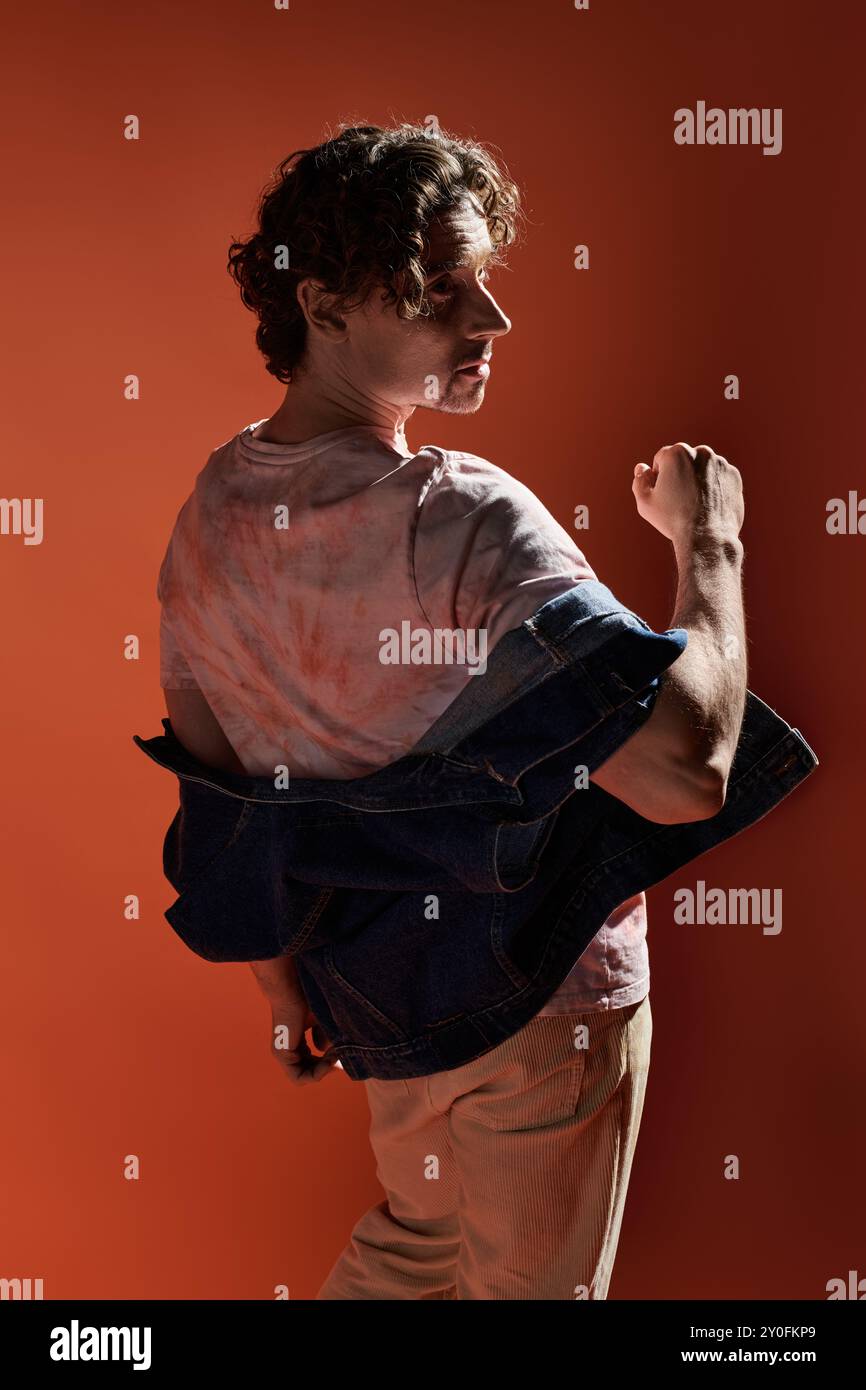 A striking man showcases deep emotion while posing against a warm ...