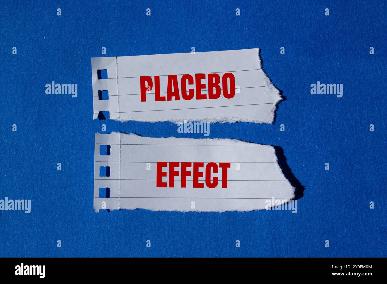 Placebo effect message written on ripped torn paper pieces with blue ...
