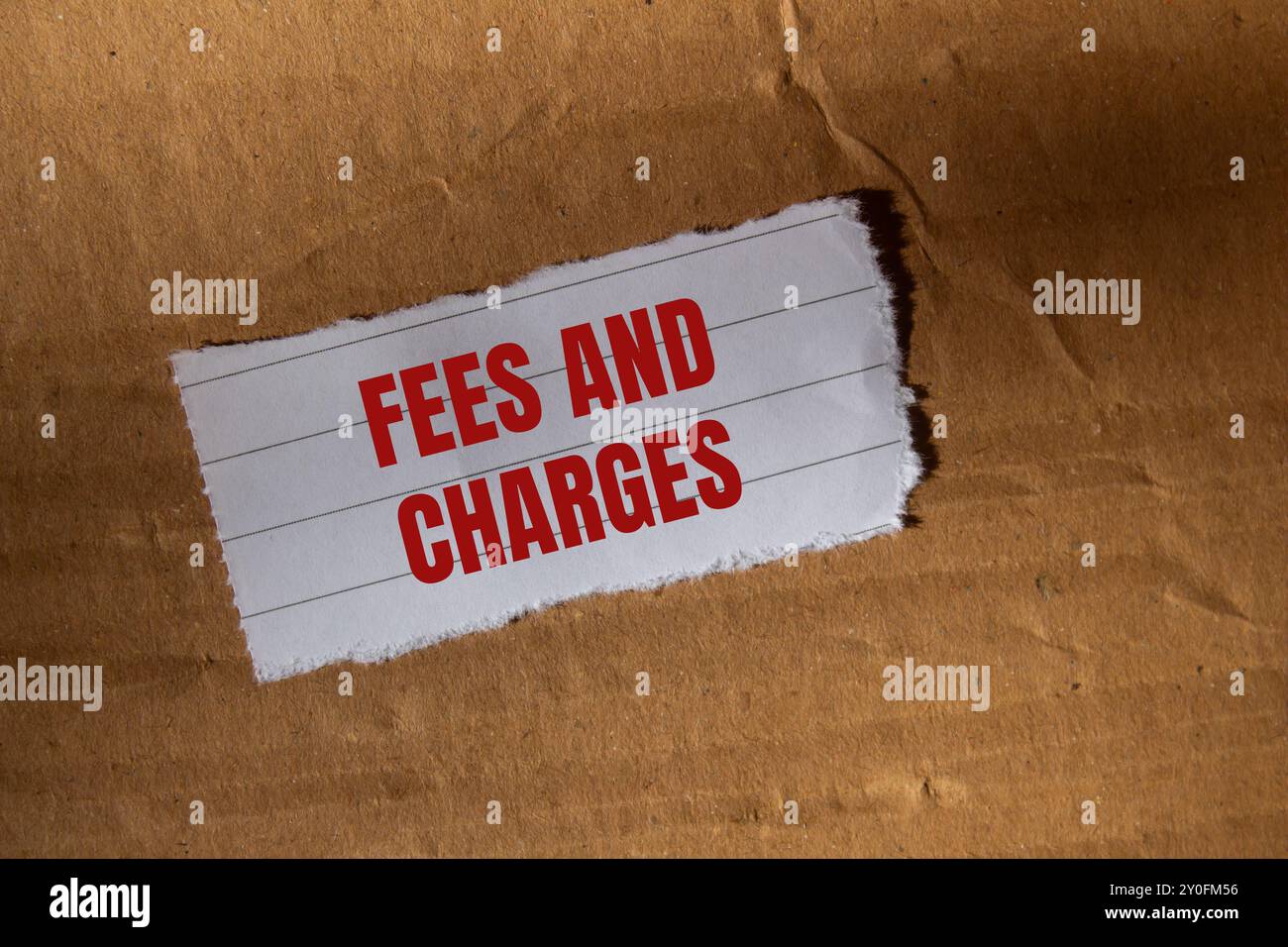 Fees and charges message written on ripped torn white paper piece with ...
