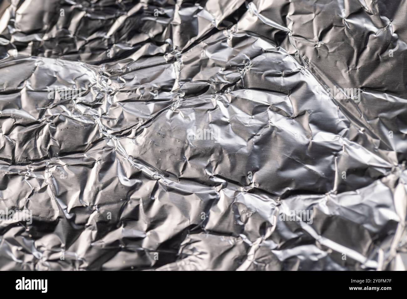 old used crumpled aluminum foil , close-up of a foil structure with ...