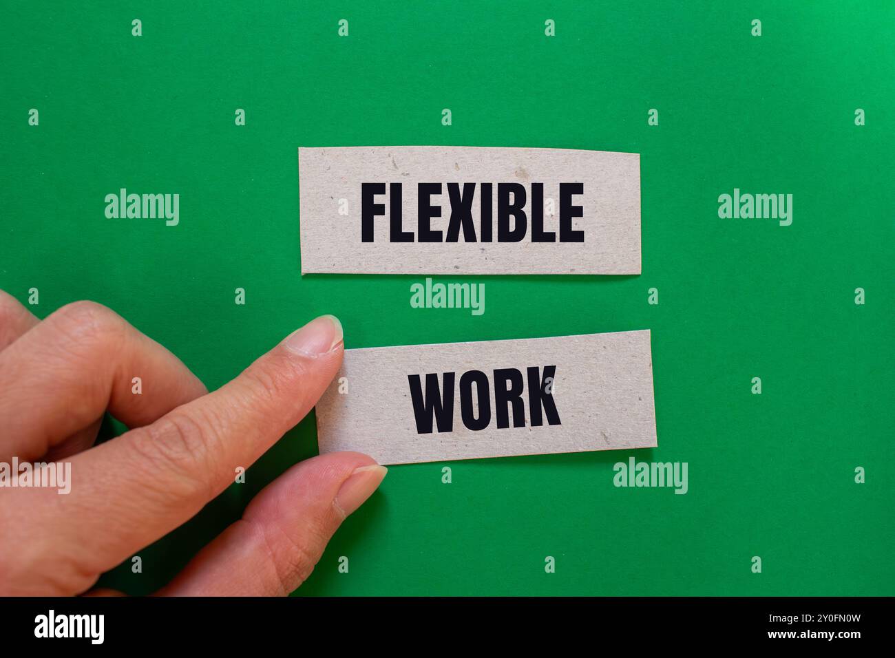 Flexible work message written on paper pieces with green background ...